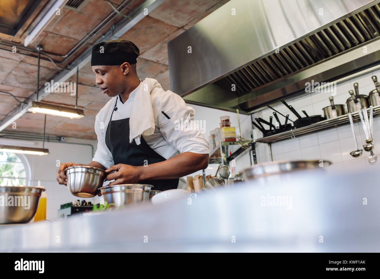 Chef cooking food in a commercial kitchen. Male cook standing by ...