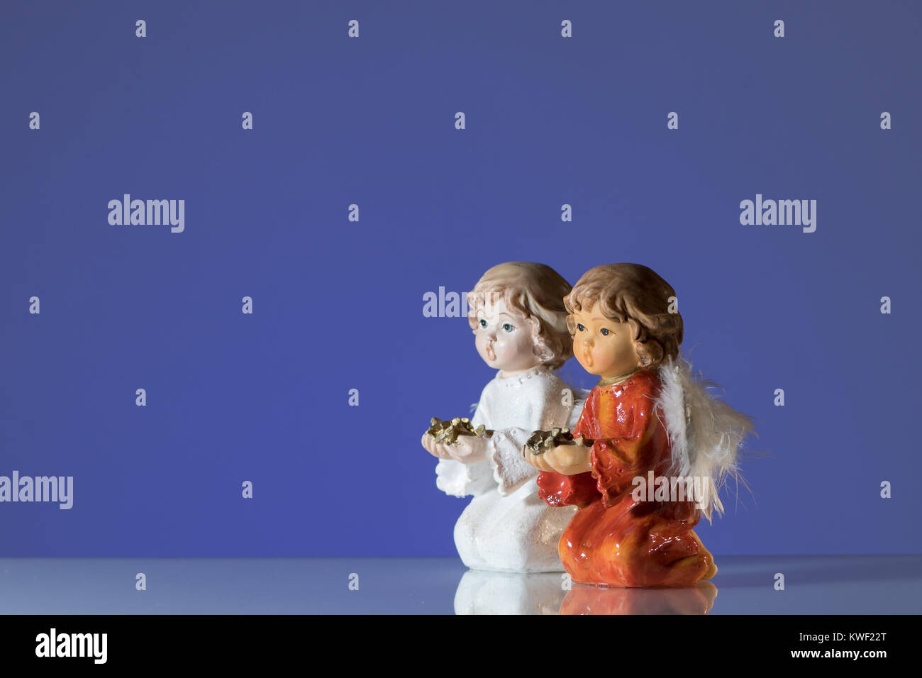 Closeup of two angels made of porcelain, blue background Stock Photo ...