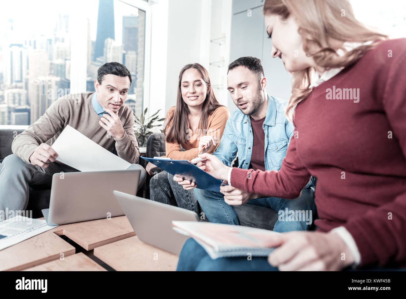 Pay attention. Reliable calm confident employees sitting together in ...