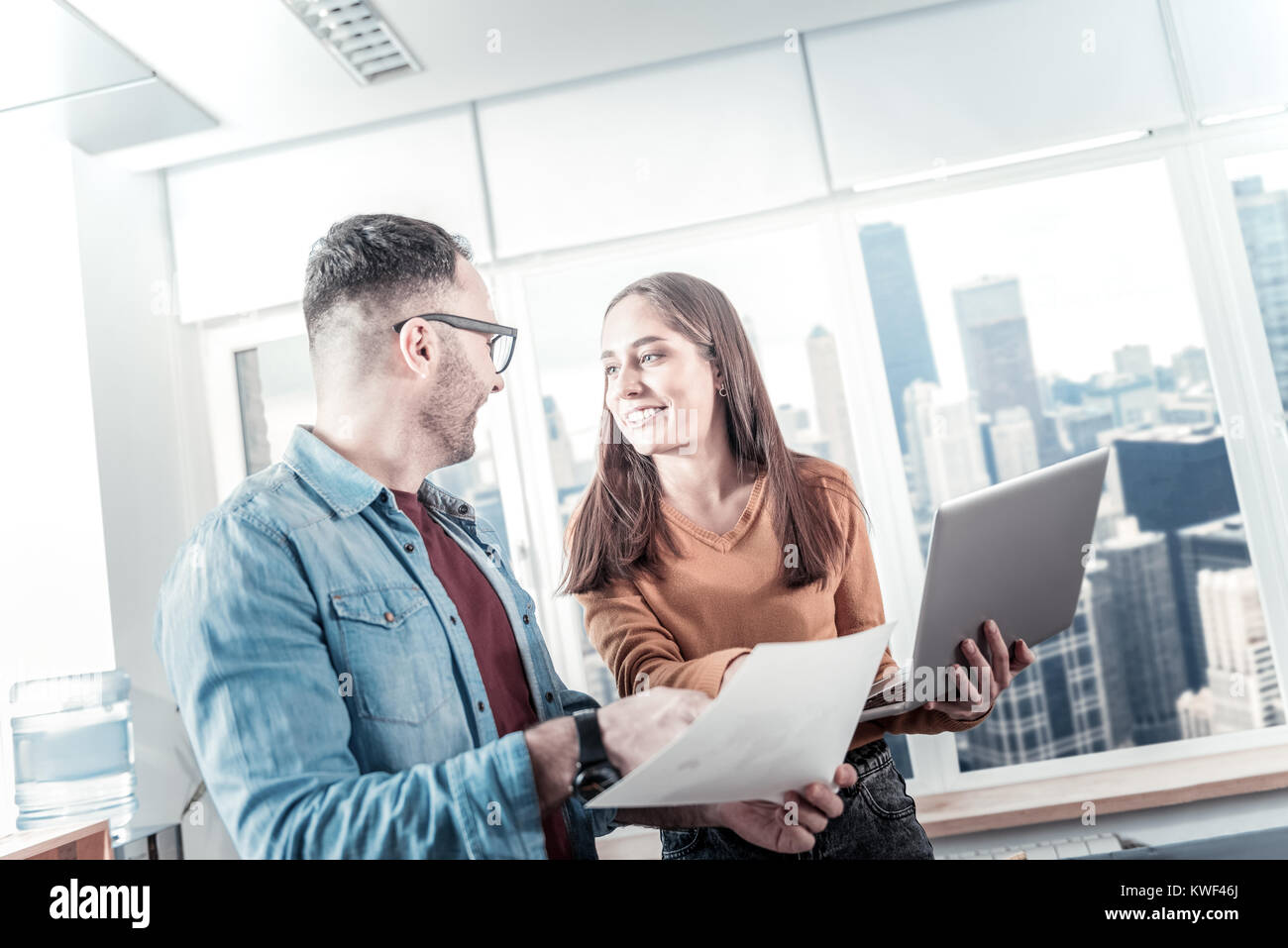 Work and partner. Joyful pretty busy woman standing with her colleague ...