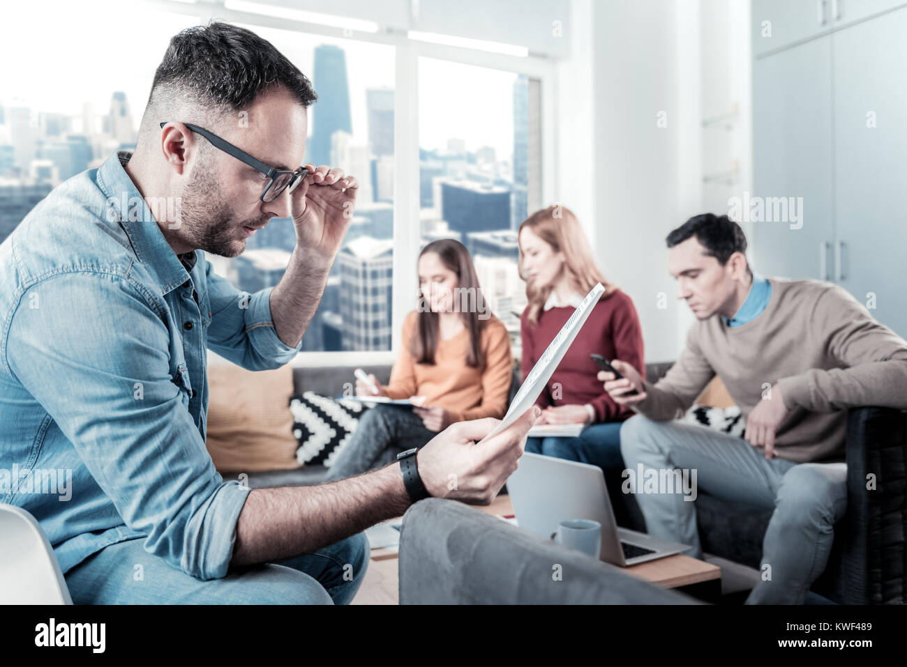 What is this. Interested handsome bespectacled man sitting in the room ...