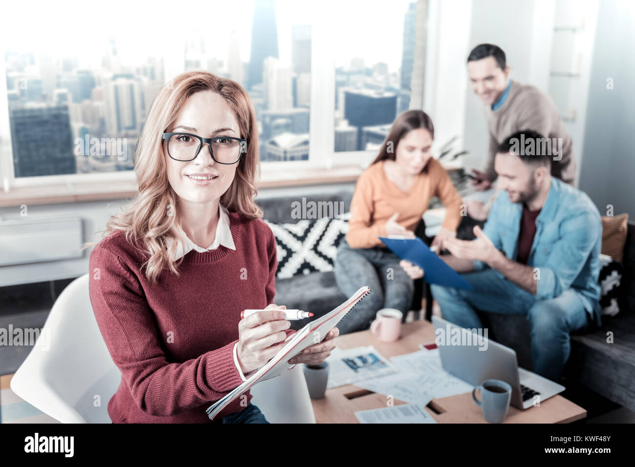 Young expert. Cute confident bespectacled woman spending time with her ...