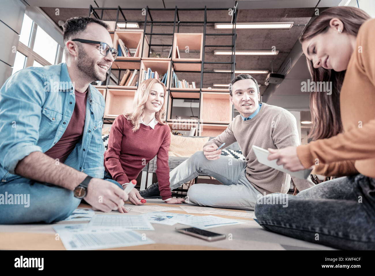 Creative mentality. Joyful thoughtful friendly workers sitting on the ...