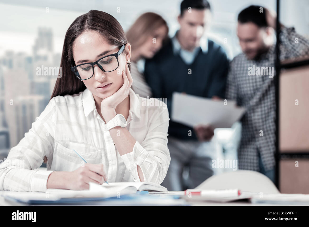 Again the same. Serious pretty bespectacled woman sitting in the office ...