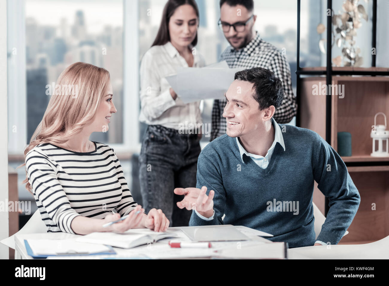 Pleasant conversation. Clever nice-looking friendly colleagues sitting ...