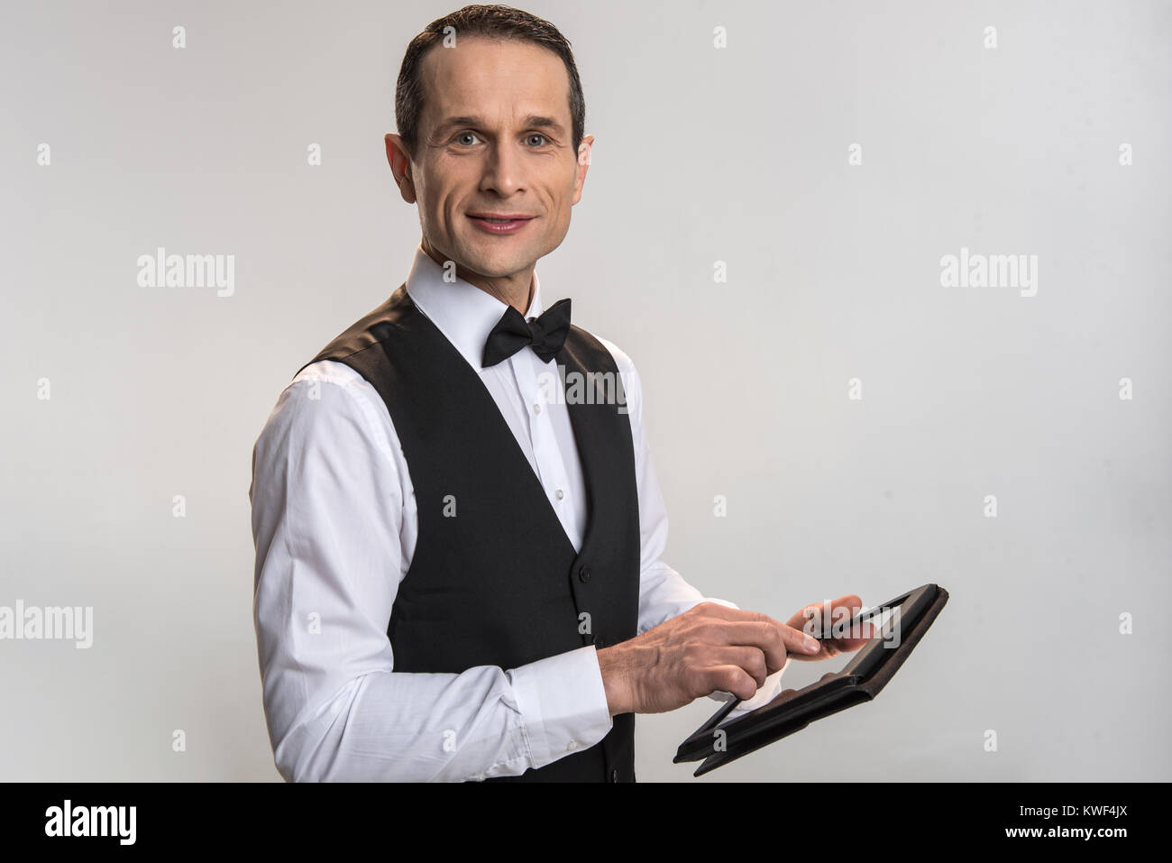 Useful tablet. Happy good looking energetic man pointing at the screen ...