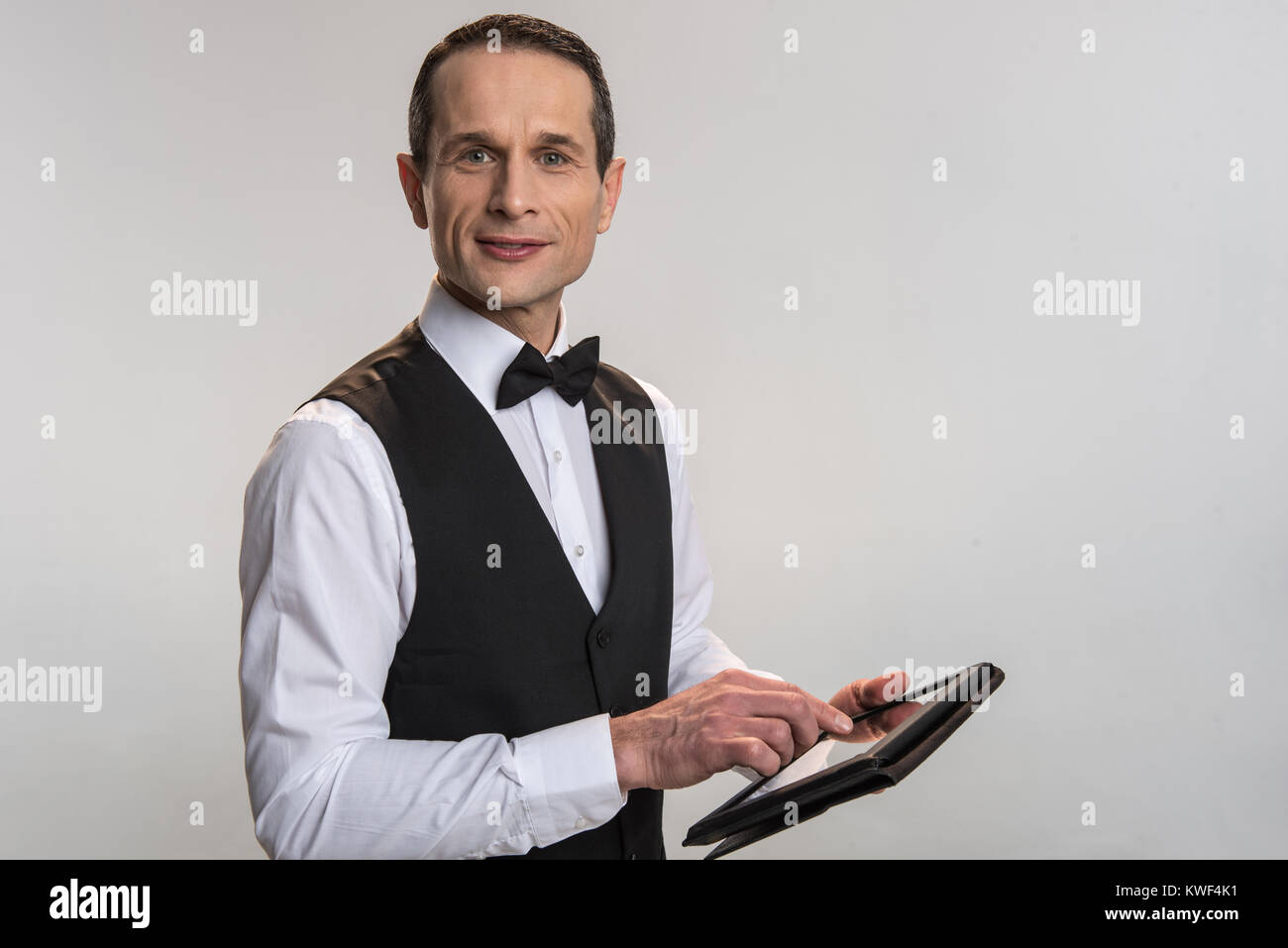 Wait one minute. Thoughtful appealing merry man posing on the grey ...