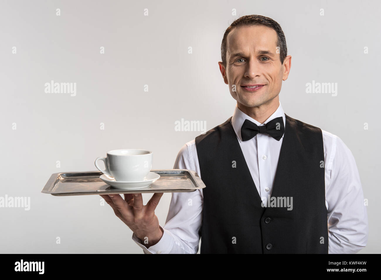 Coffee sir. Optimistic elegant male waiter smiling on the grey ...