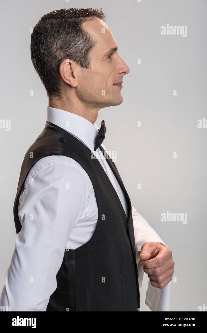 Ready to serve. Optimistic good looking male waiter staying on the ...