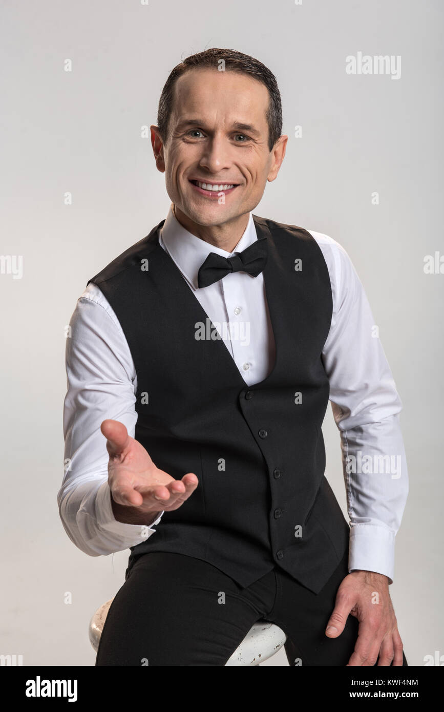 Be with me. Adorable handsome jolly man grinning on the chair while ...