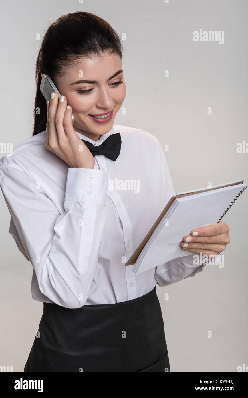 Listening to you. Charming cheerful jolly waitress holding notebook ...