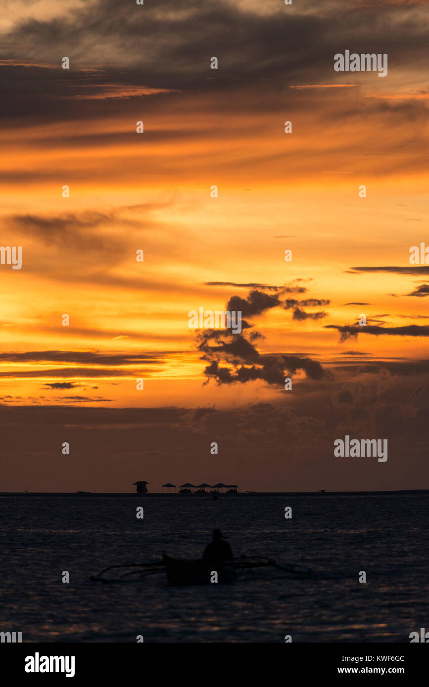 Three fishermen in a small bangka boat on their way to their fishing ...