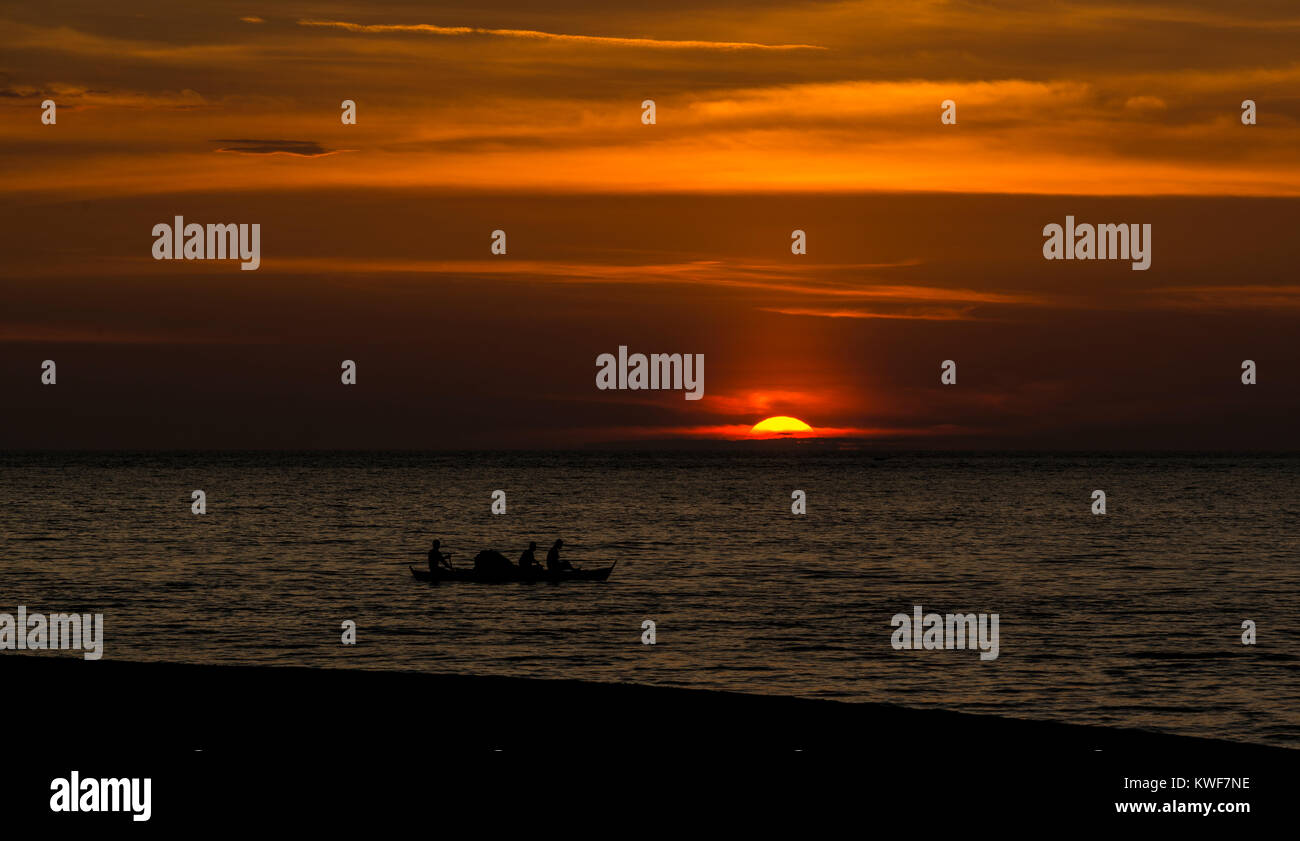 Three fishermen in a small bangka boat on their way to their fishing ...