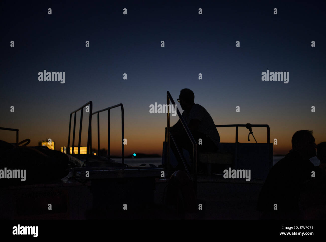 Man on boat at sunset in Ibiza Stock Photo - Alamy