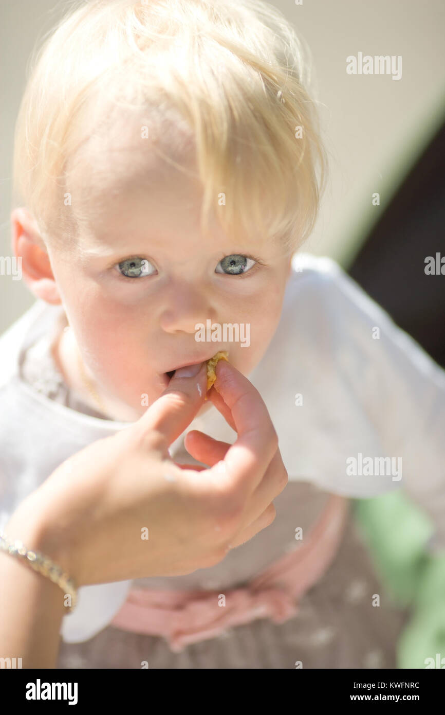 Toddler Eating from mother's hands Stock Photo - Alamy