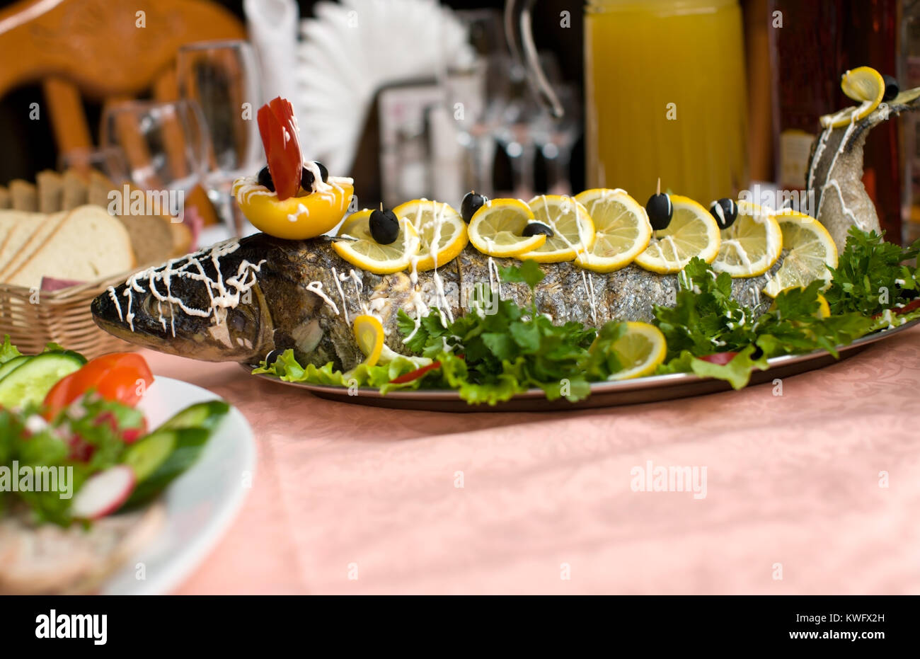baked fish full body on plate in restaurant Stock Photo - Alamy