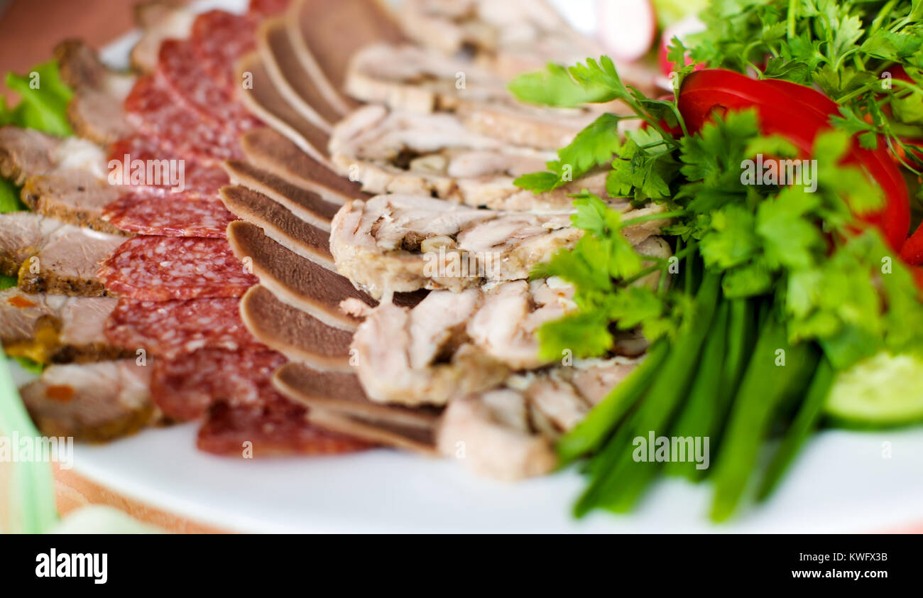 Meat and bloated sausage Slices on plate macro shot Stock Photo - Alamy