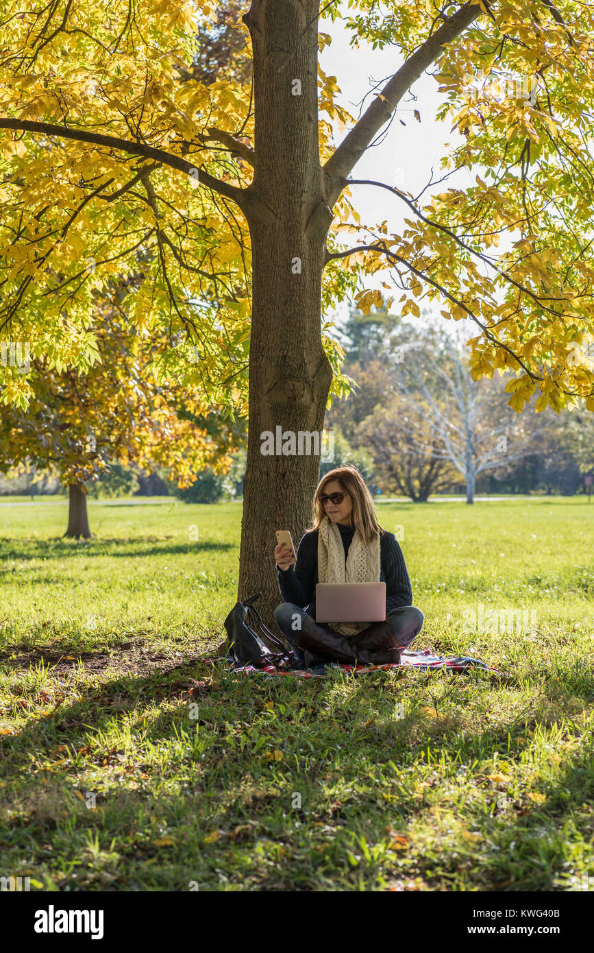 Woman sitting under tree holding hi-res stock photography and images ...