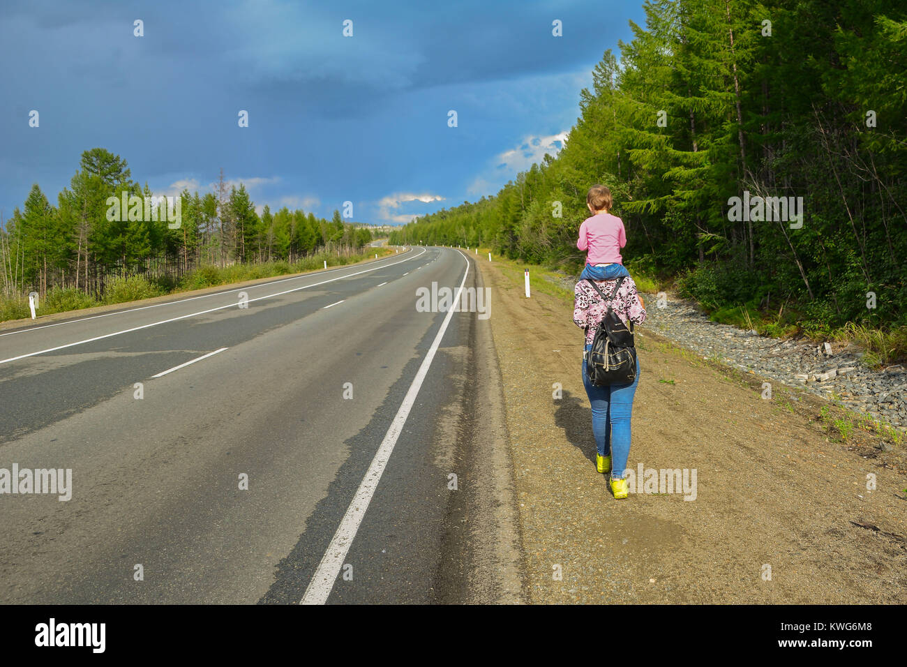 two sisters go on road, back to a camera, on nature, in the summer ...