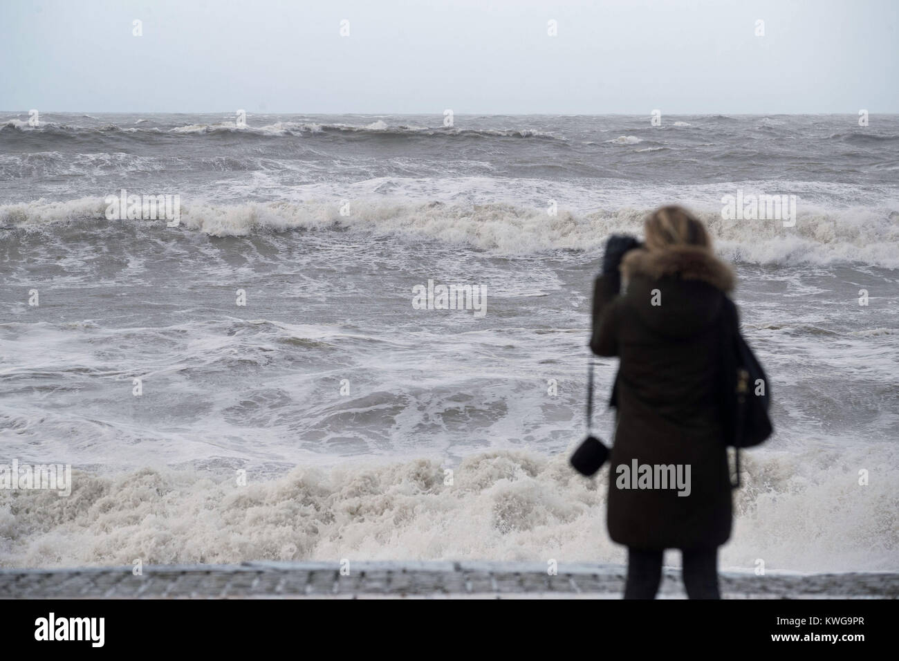 A women photographs the rough seas in Aberystwyth in west Wales as ...