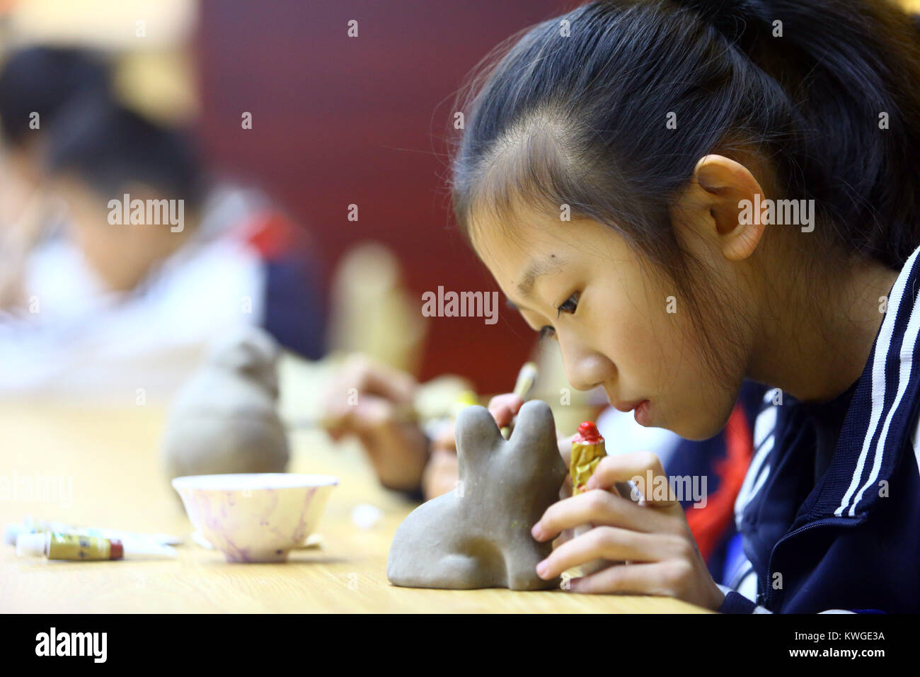 Tianjin. 3rd Jan, 2018. A girl learns to make clay sculpture at Puyu ...