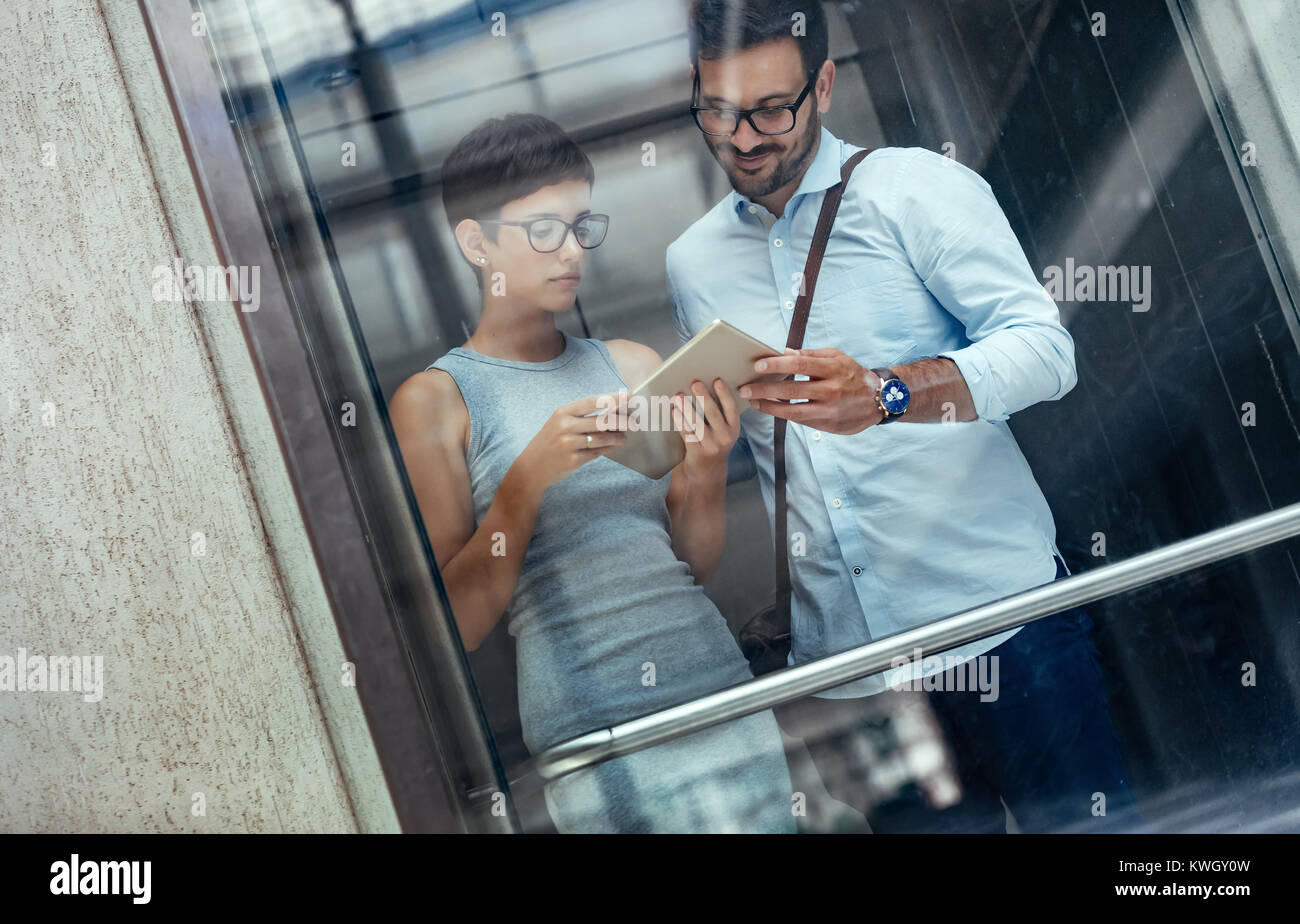 Picture of young businesspeople talking in elevator Stock Photo - Alamy