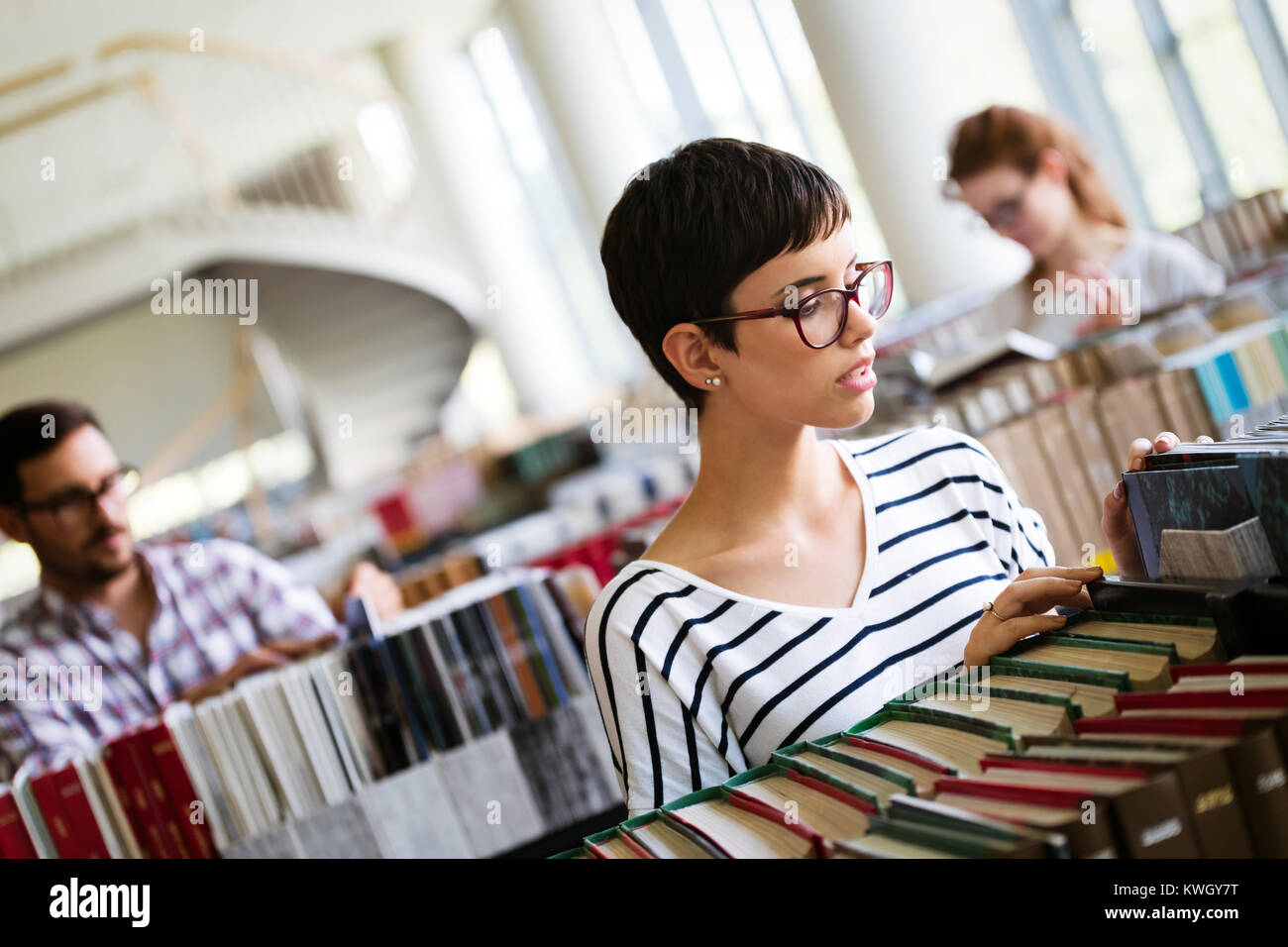 Woman reading a book at the library Stock Photo - Alamy