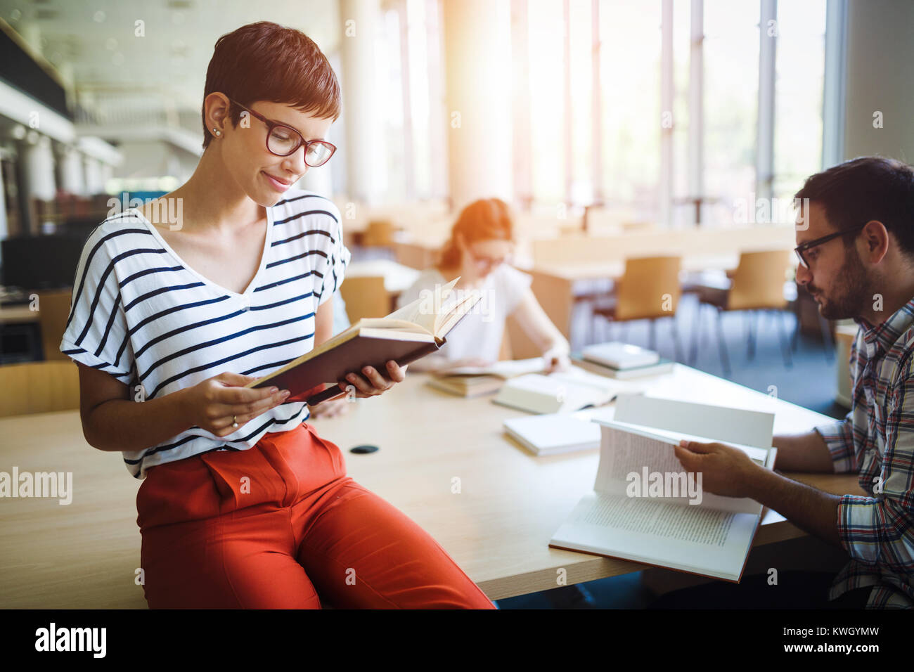 Woman reading a book at the library Stock Photo - Alamy