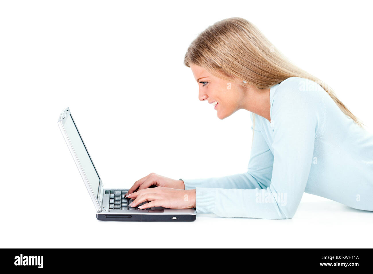 Blonde girl working on laptop, white background Stock Photo - Alamy