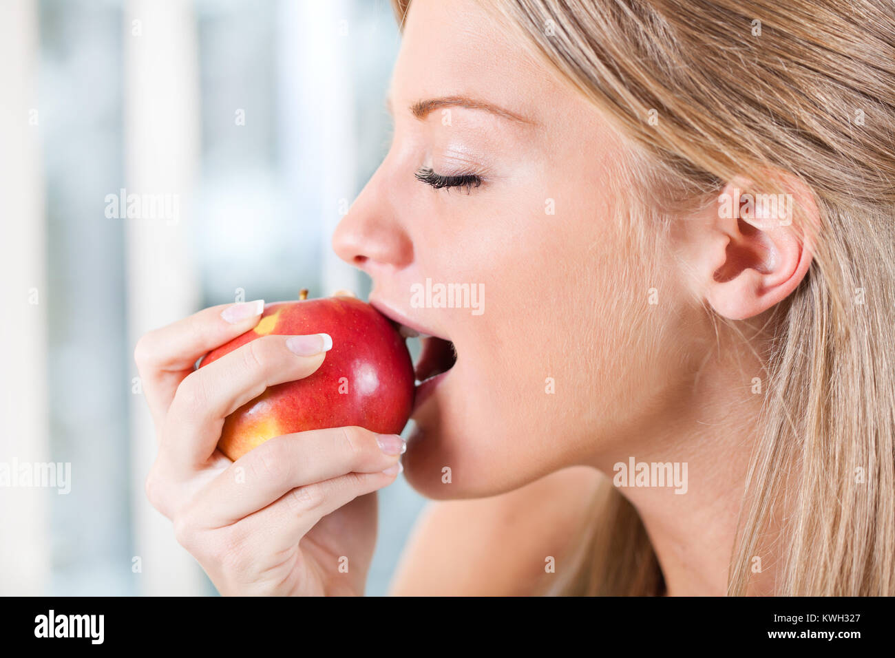 Woman eating an apple Stock Photo - Alamy