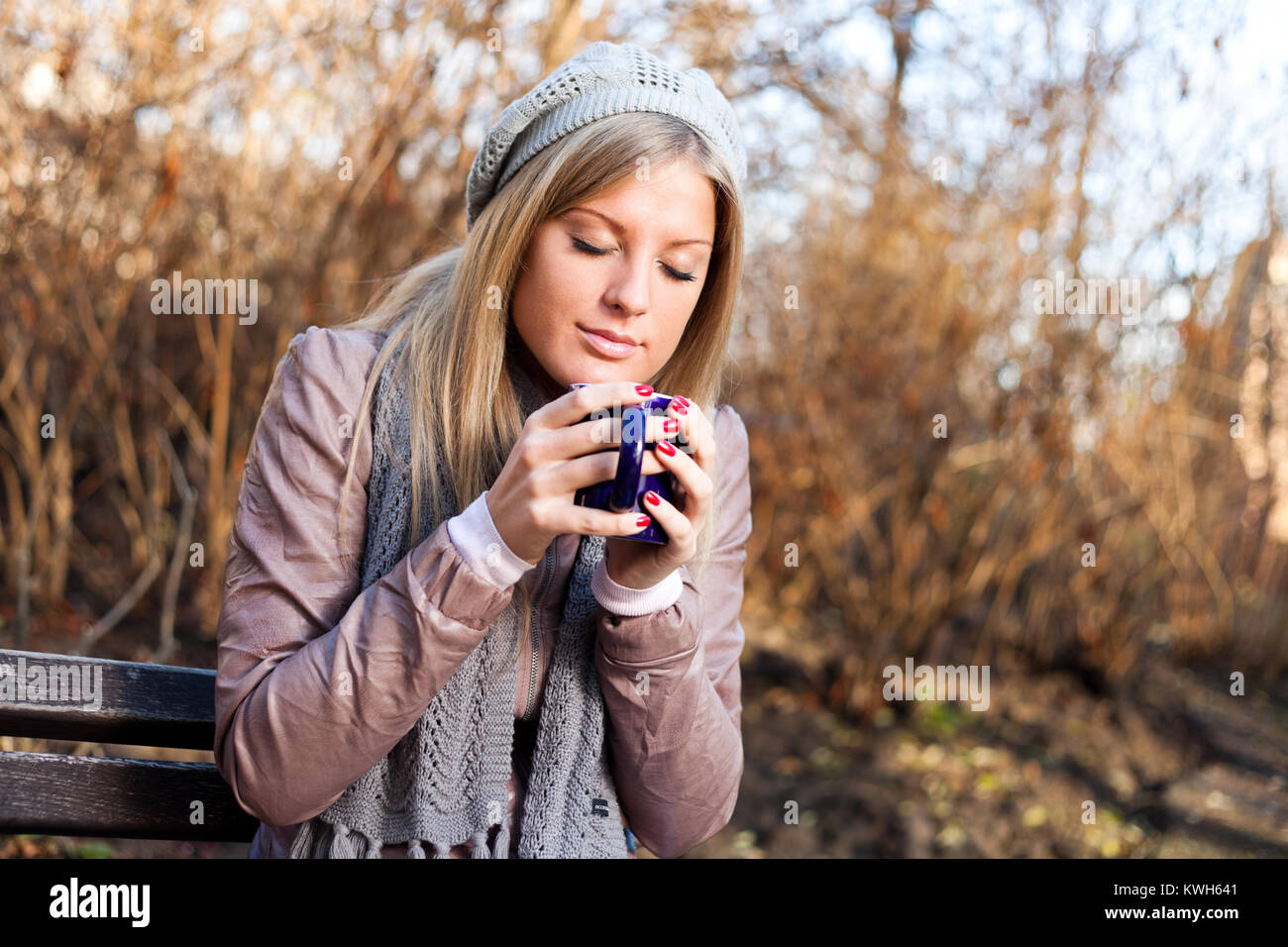 Young woman drinking tea in park Stock Photo - Alamy