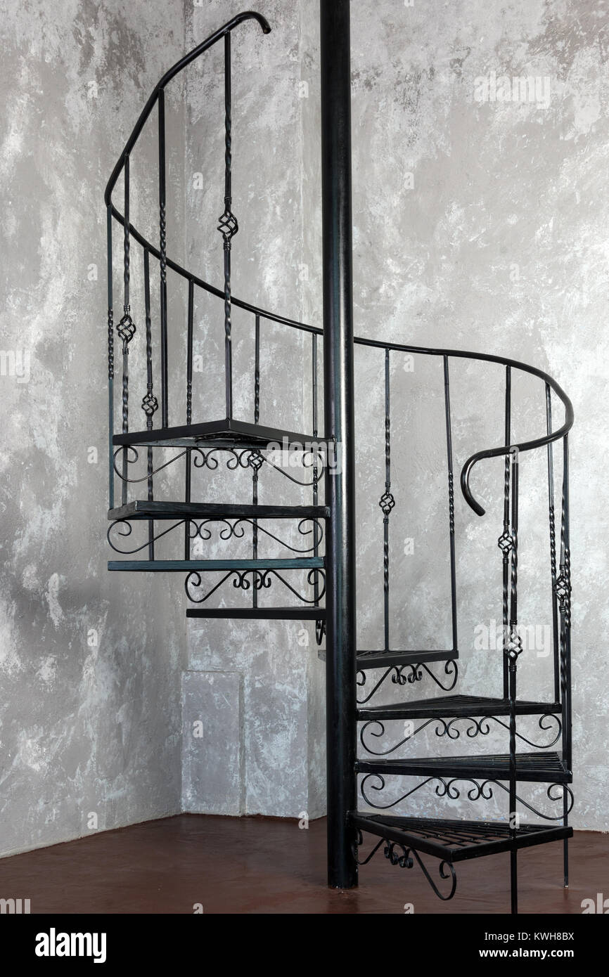 Vertical view of a metal dark spiral staircase in loft interior Stock ...