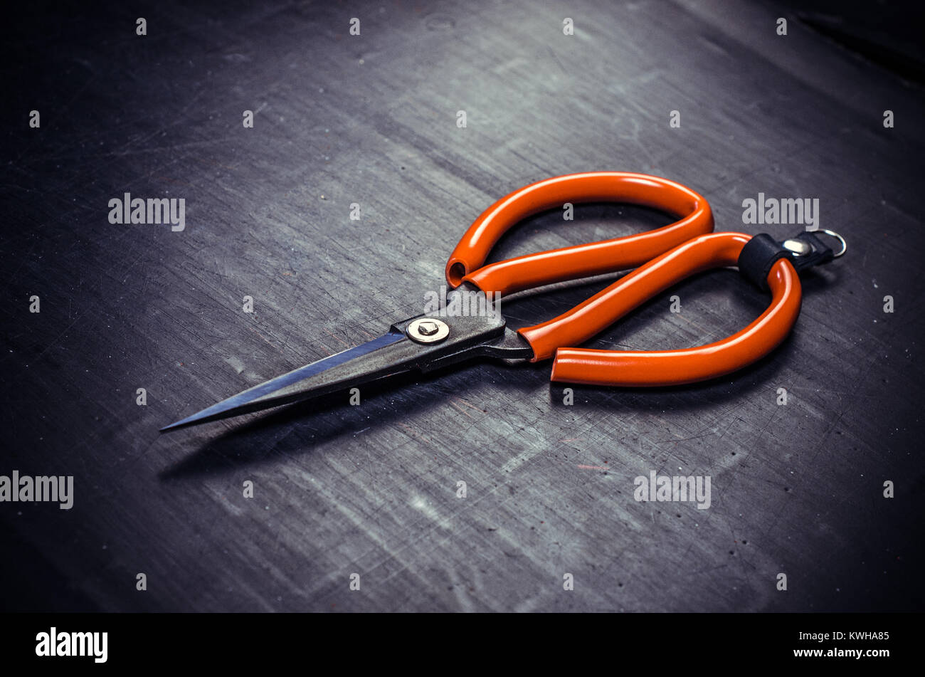 Orange scissors on work desk background Stock Photo - Alamy