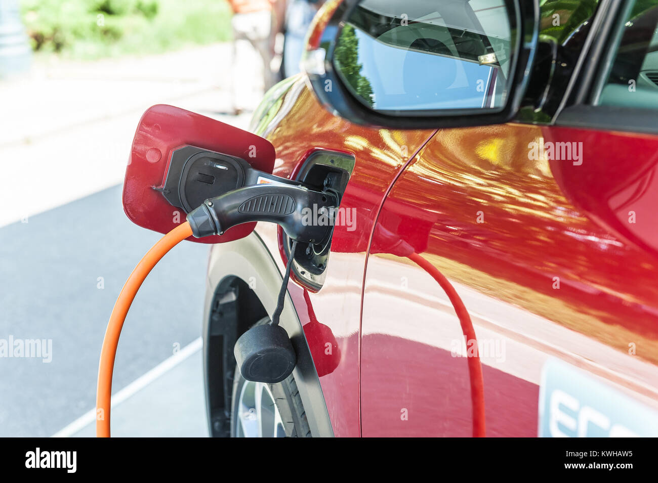 Power supply for electric car charging with red car Stock Photo - Alamy