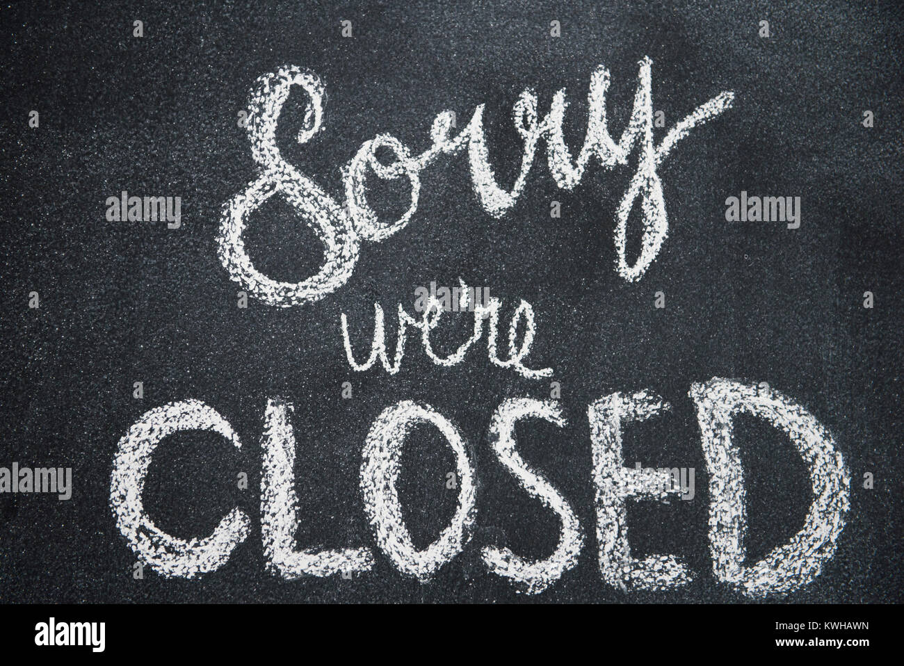 Sorry we're closed is shown written in white chalk on a blackboard ...