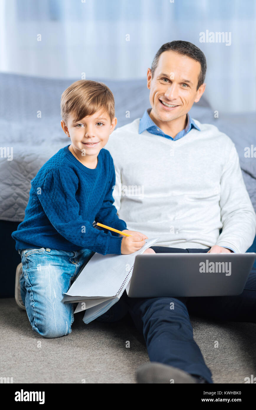 Cheerful father and son posing while copying image from laptop Stock ...