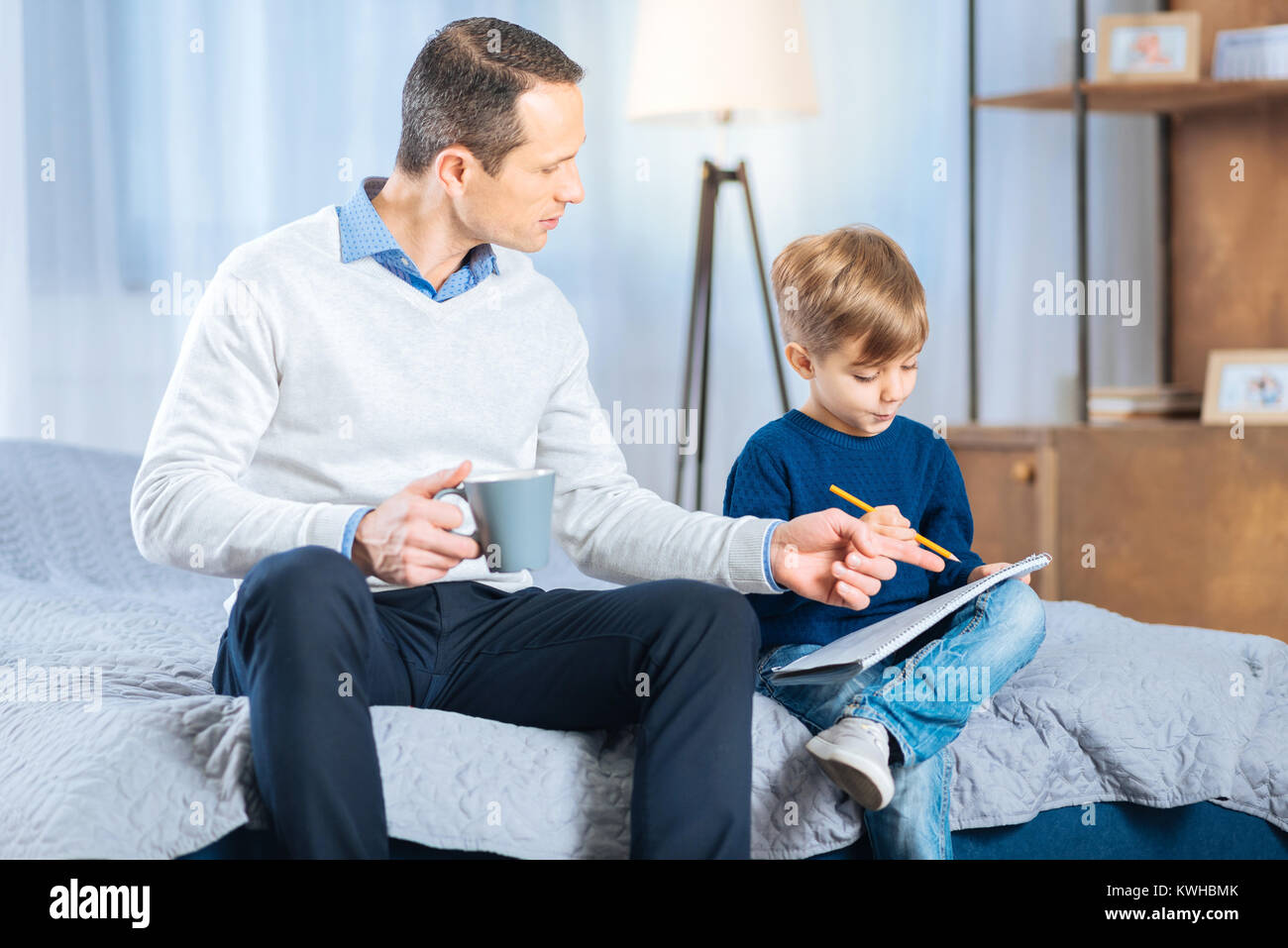 Caring father giving his son drawing tips Stock Photo - Alamy