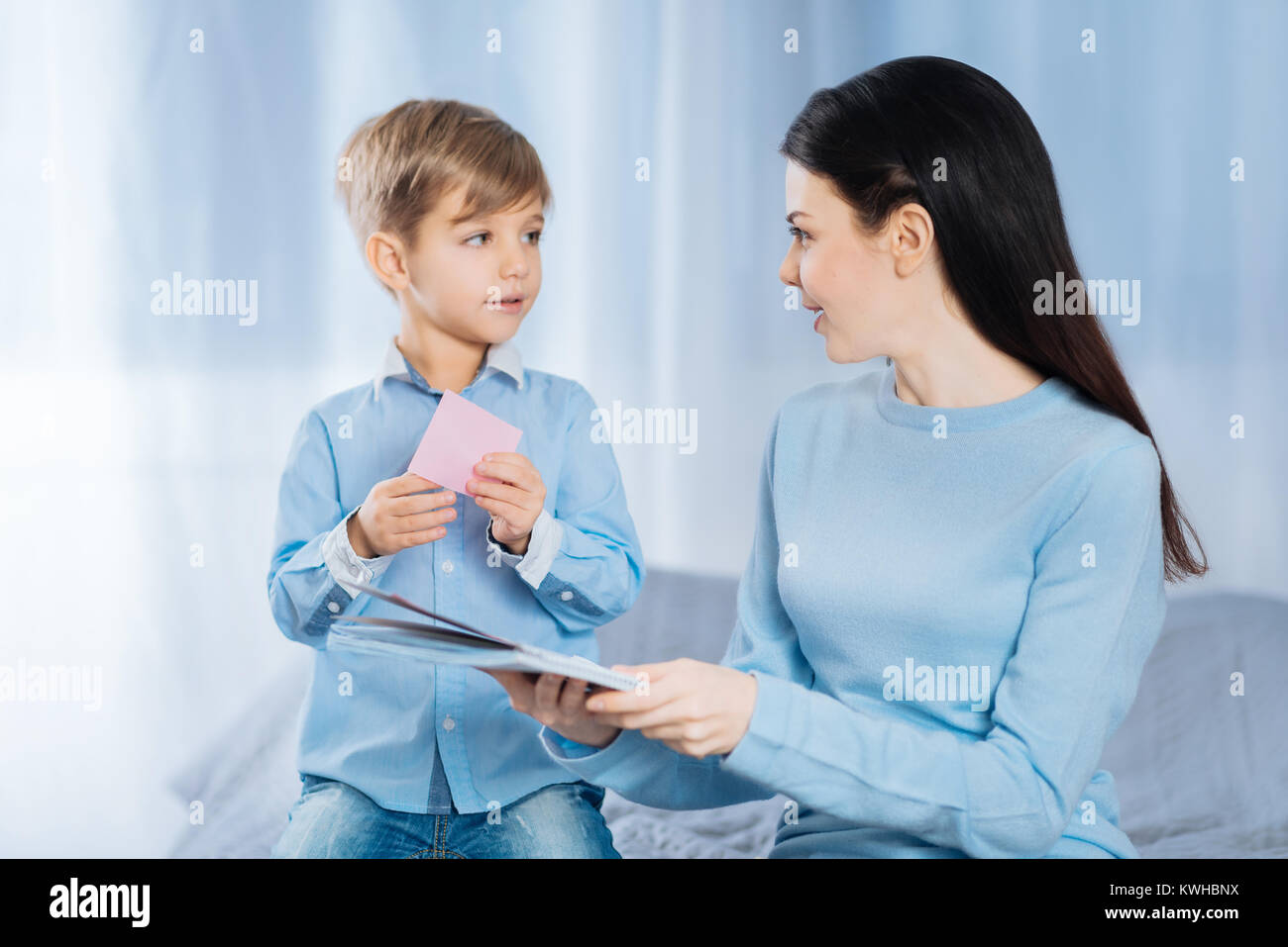 Lovable boy and his mother talking while preparing for studying Stock ...
