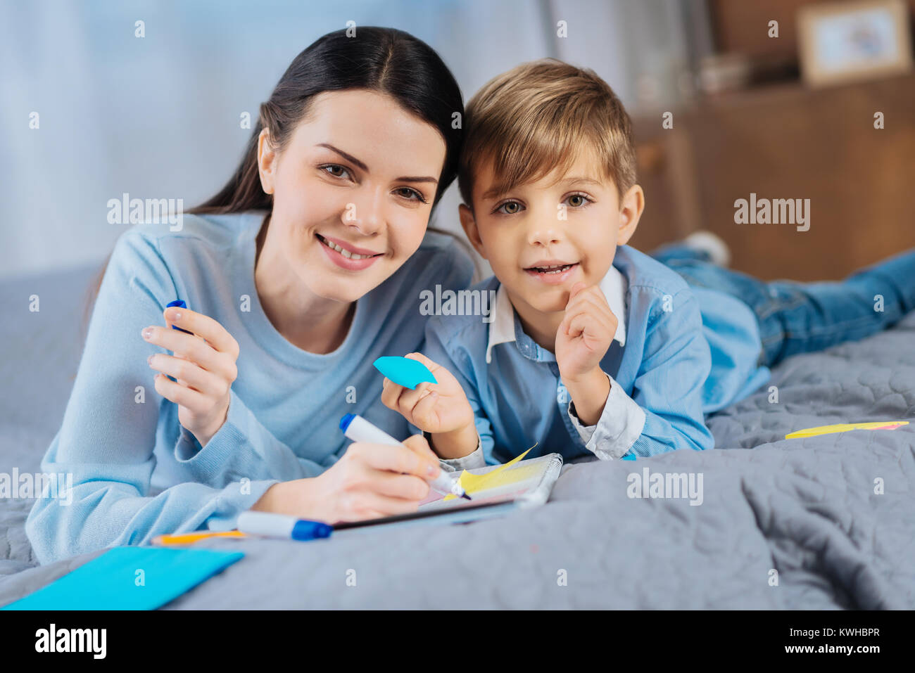 Happy mother and son posing while writing memos in notebook Stock Photo ...