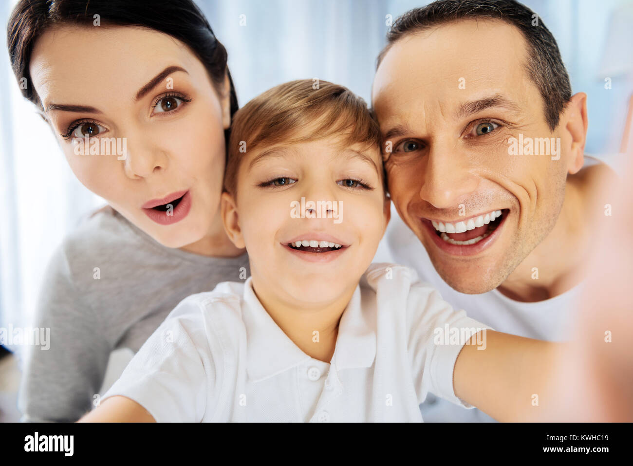 Cheerful boy taking close-up selfie with parents Stock Photo - Alamy