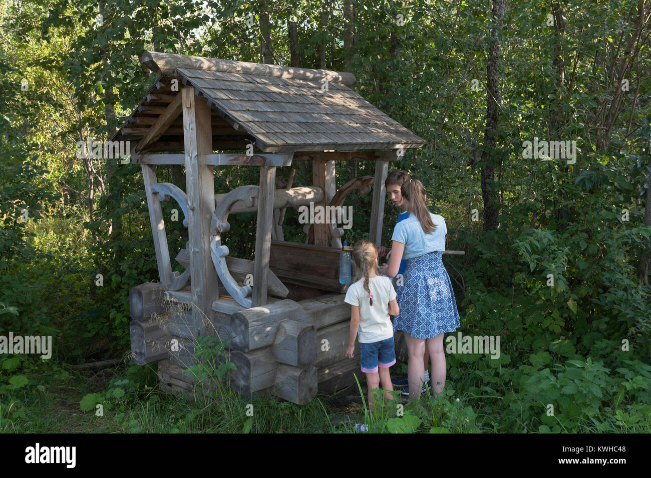 Children are gaining spring water from a spring in the form of the well ...