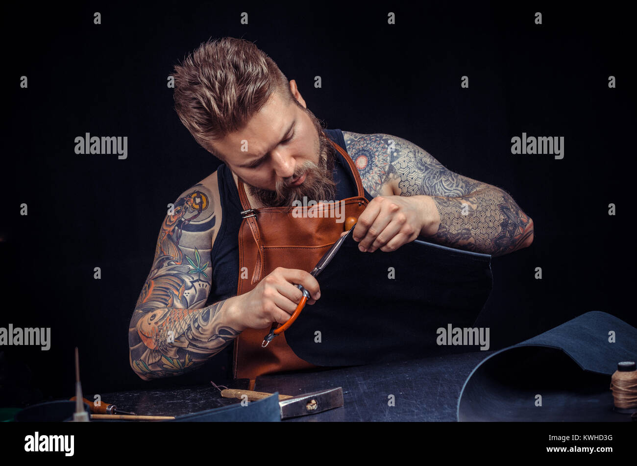 Leather master working on a new leather product Stock Photo - Alamy