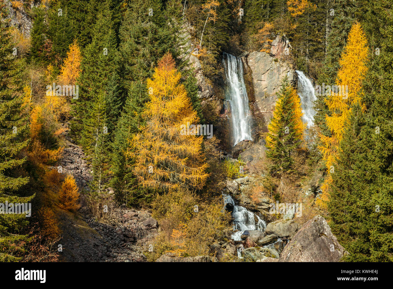 Fall foliage color in the larch trees and a Dolomite mountain waterfall ...