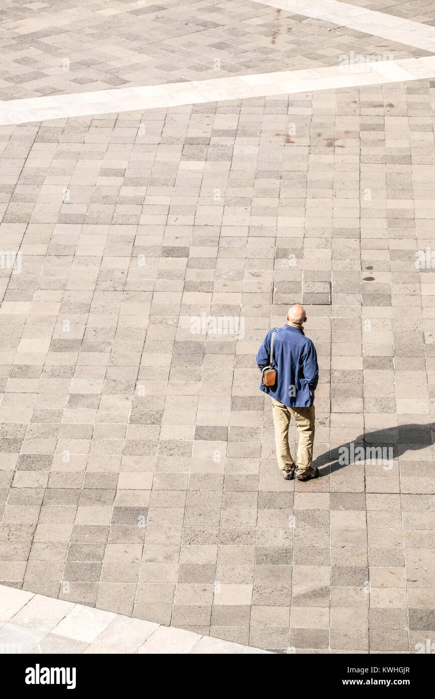 A lone man walking on an empty square Stock Photo - Alamy