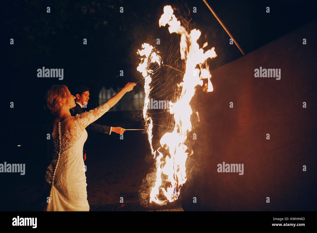 the bride and groom light a fire heart Stock Photo - Alamy