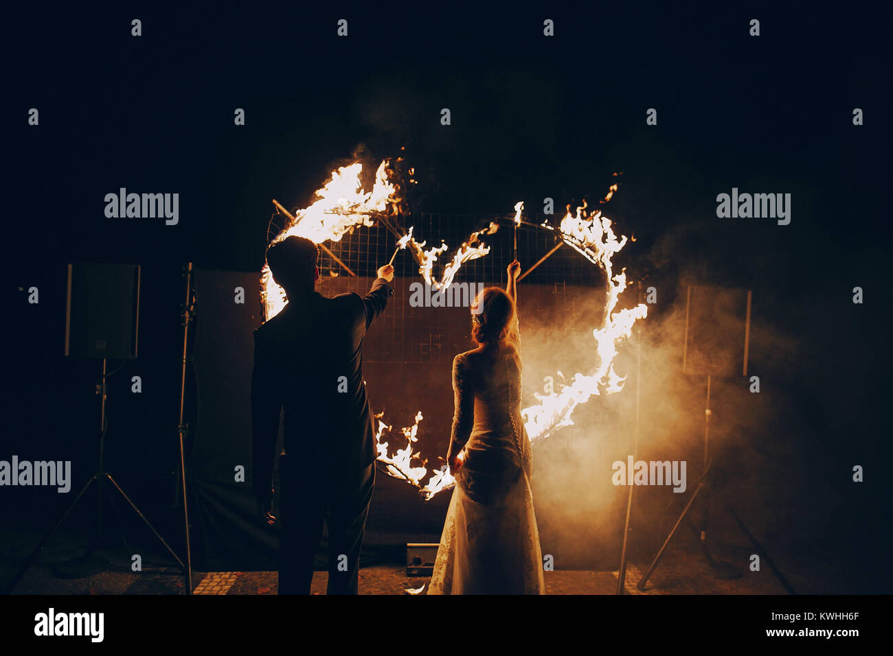 the bride and groom light a fire heart Stock Photo - Alamy