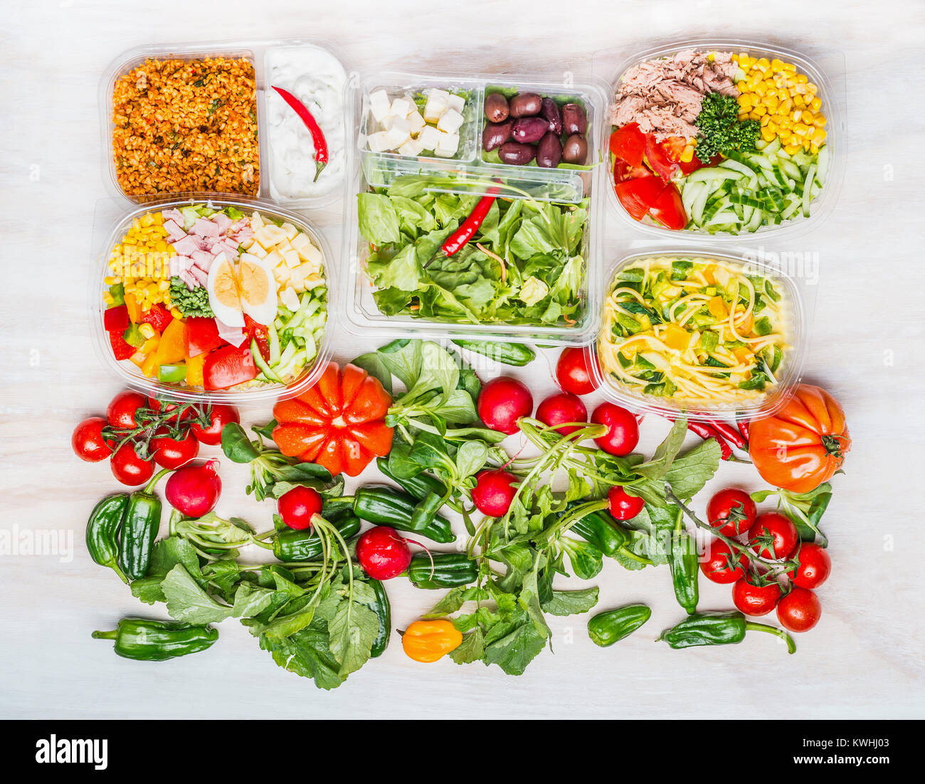 Variety of Healthy salads in lunch boxes with ingredients white wooden ...