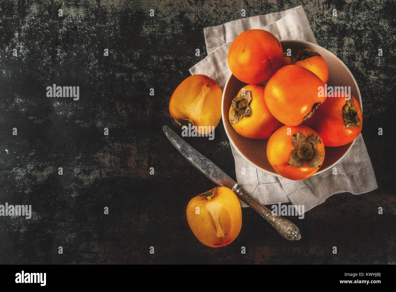 Delicious raw ripe persimmon fruit on dark rusty metal background copy ...