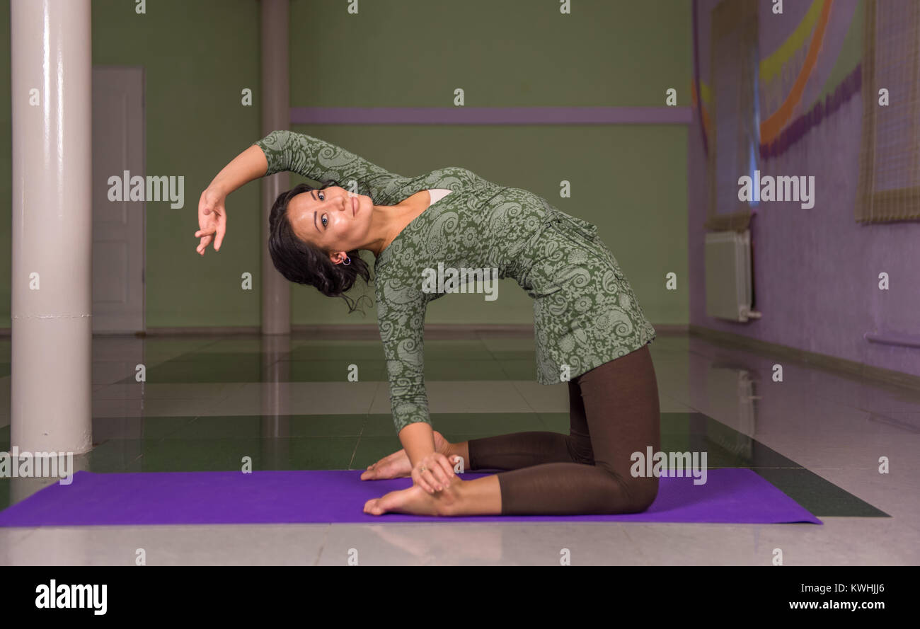 Yoga teacher demonstrating yoga asana in a studio Stock Photo - Alamy