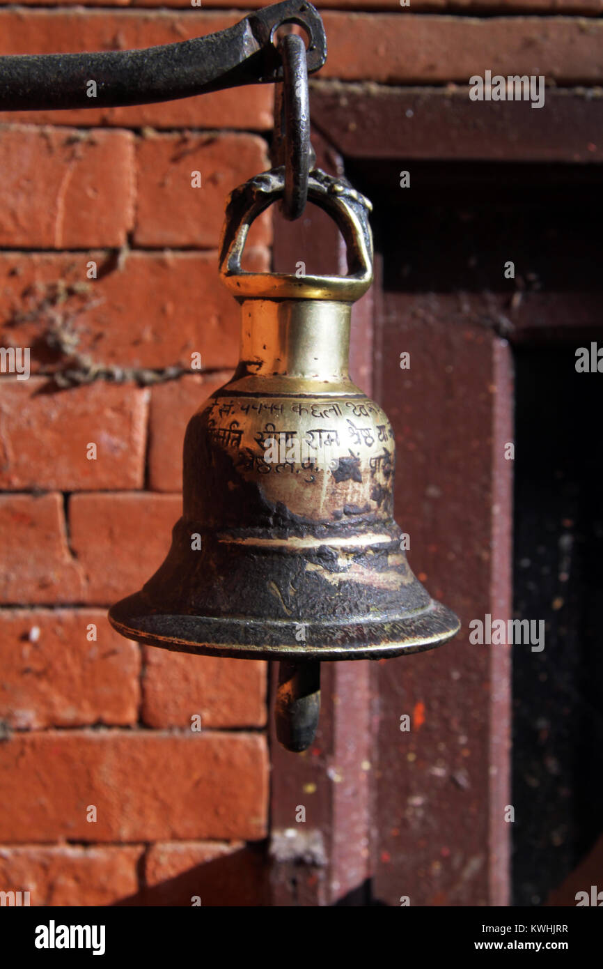 Small bronze bell hang near the brick wall in the temple Stock Photo ...